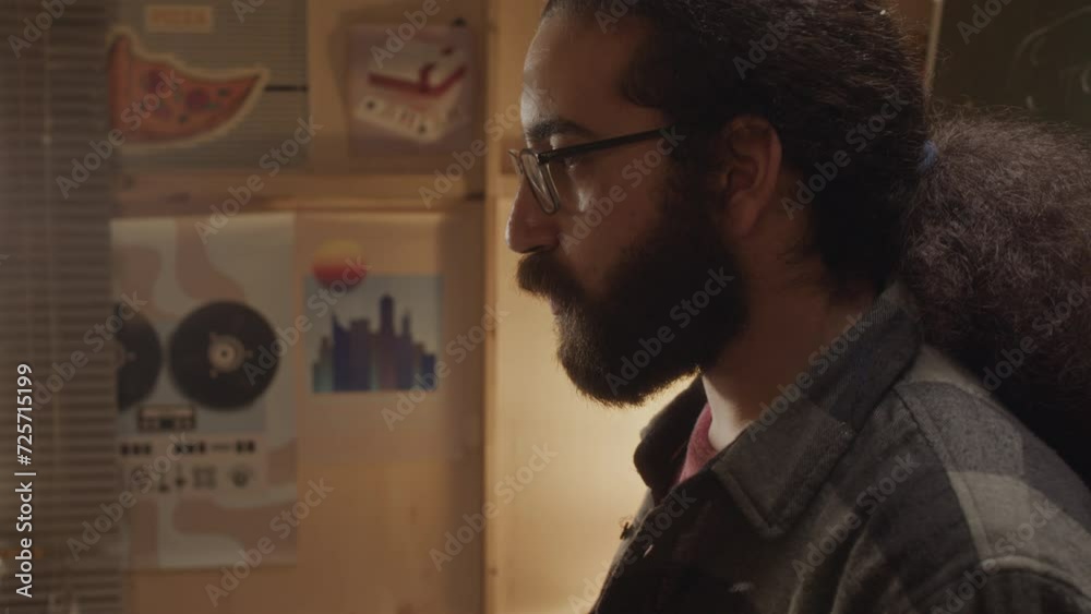 Tilt up of long haired Middle Eastern male programmer wearing retro ...