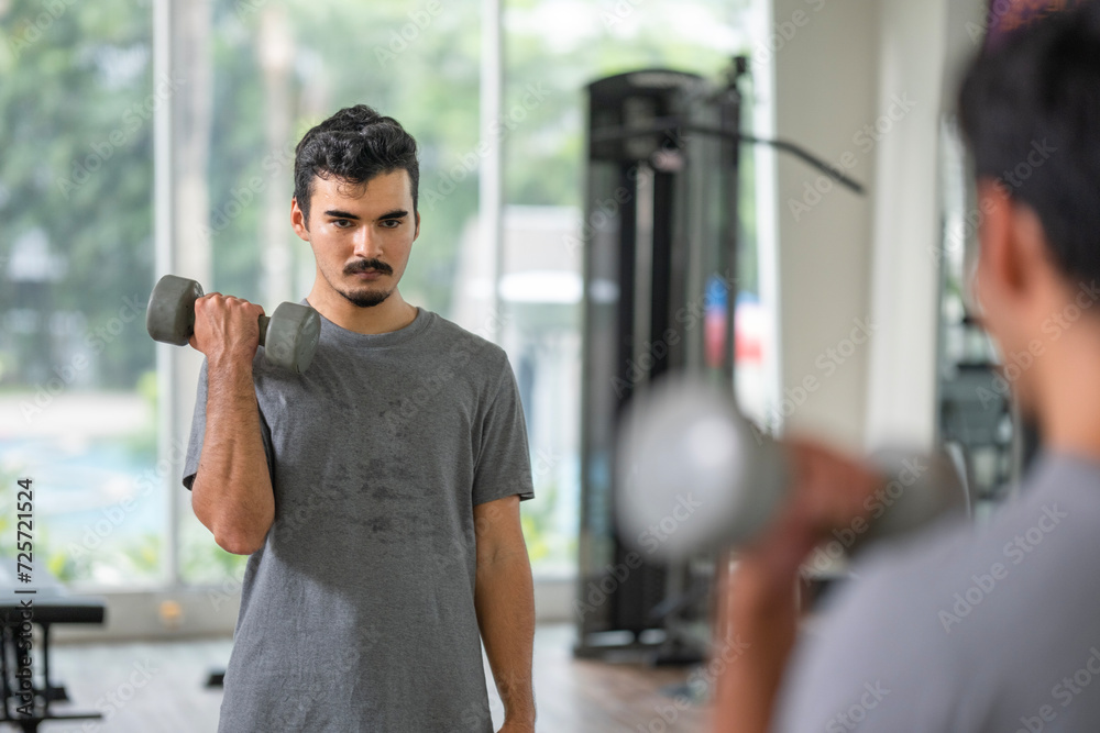 Intense concentration is captured as a man performs bicep curls with ...