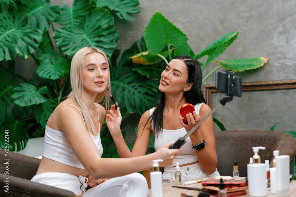 Two beautiful content creator making natural beauty and cosmetic tutorial on green plant garden ...