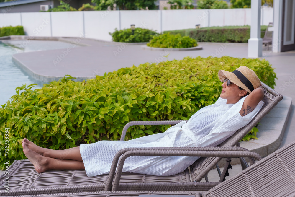 Beautiful Hispanic woman, wearing white robe, sunglasses, hat shield ...
