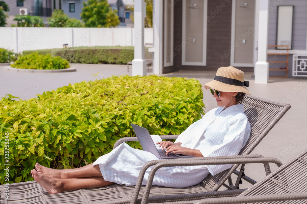 Beautiful Hispanic woman in a white coat works using a laptop computer ...