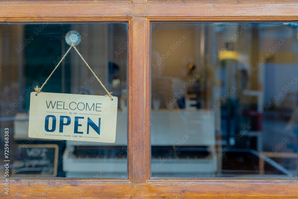 Brown wooden sign board with word "Welcome we are OPEN please come in ...