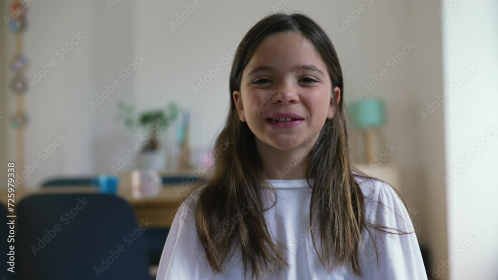 One happy little girl smiling and laughing at camera standing indoor at ...