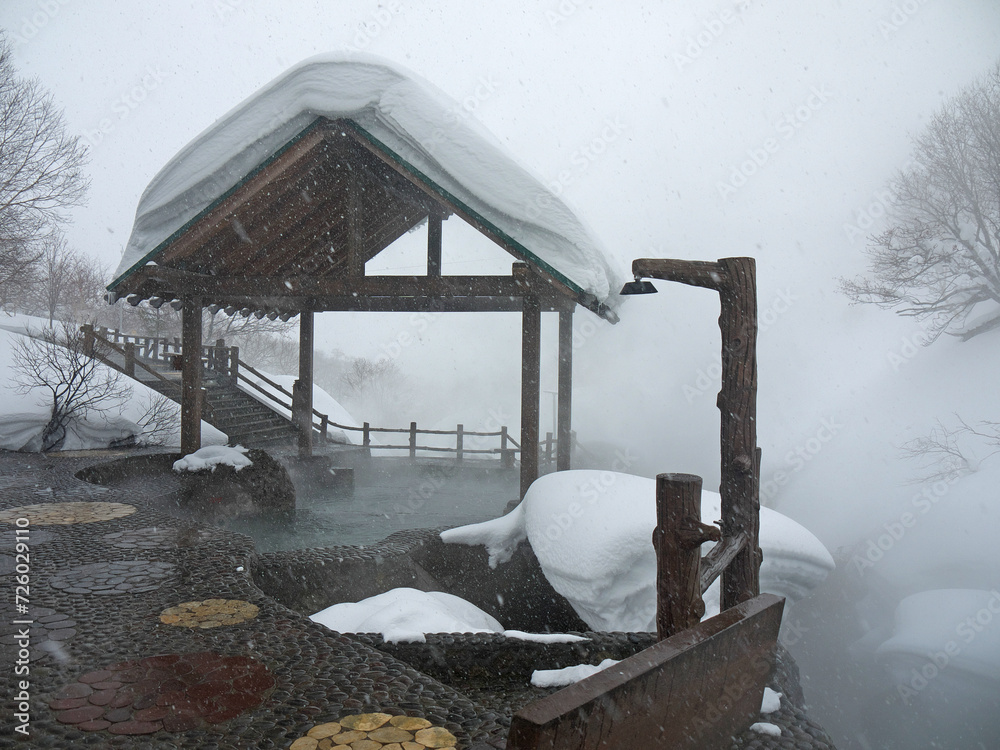 Traditional japanese outdoor onsen bath with and big snowdrift on the ...