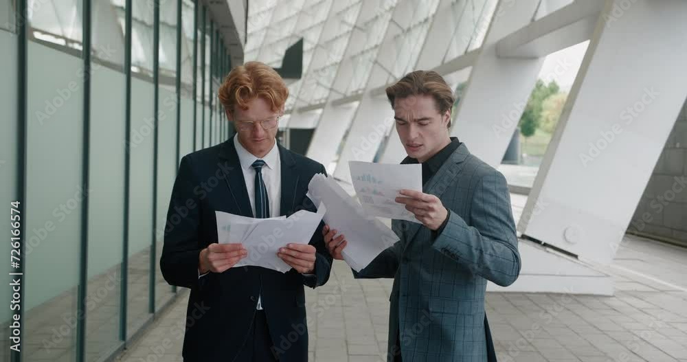 Vidéo Stock Side by side two coworkers tackle paperwork testament to ...