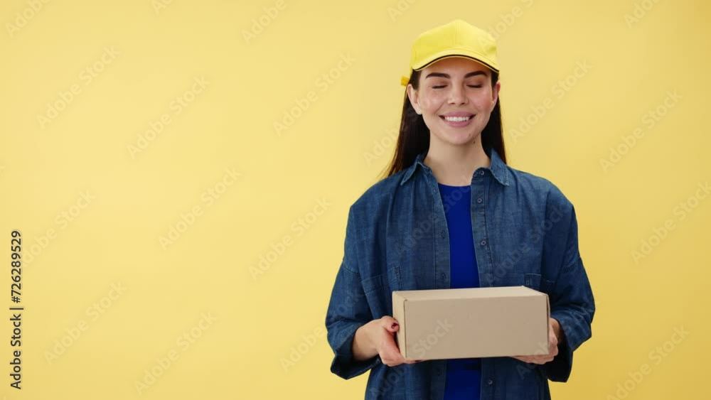Portrait of female delivery worker wearing blue shirt and yellow cap ...