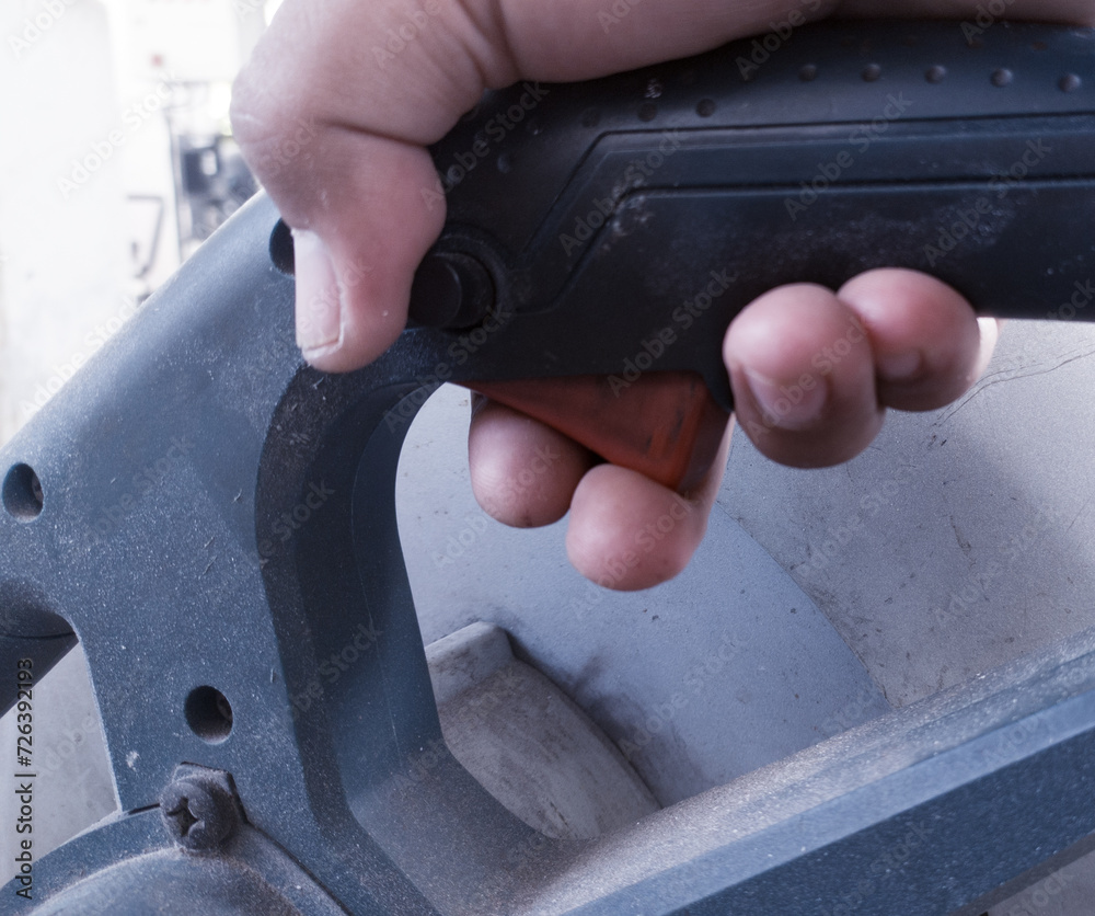 The hand push the power switch and locking button on the electric ...