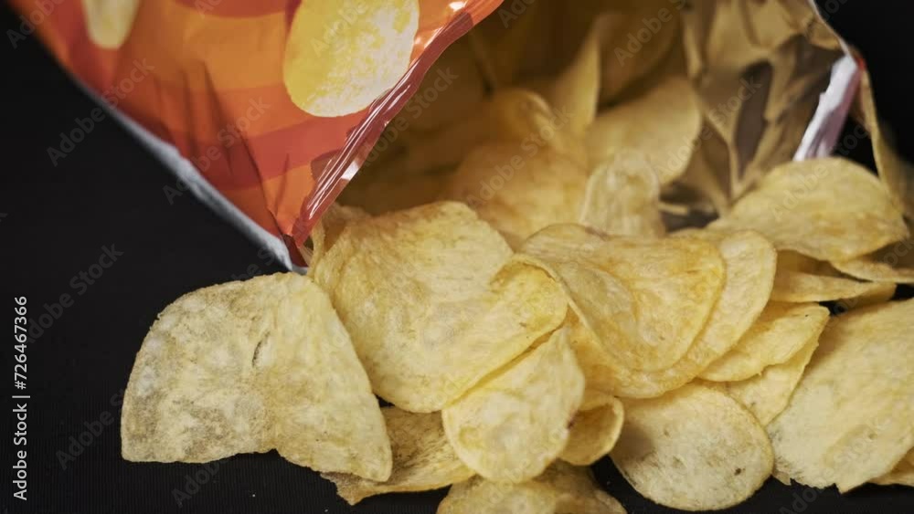 Vidéo Stock An open chips pack rotates on a black background close-up ...