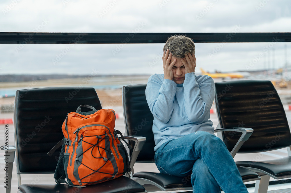 Sad Traveler sitting in an airport, waiting for a flight, walking ...