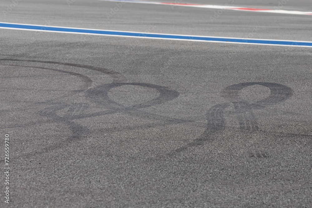 Close-up of tire tracks on a paved asphalt road, race track texture and ...