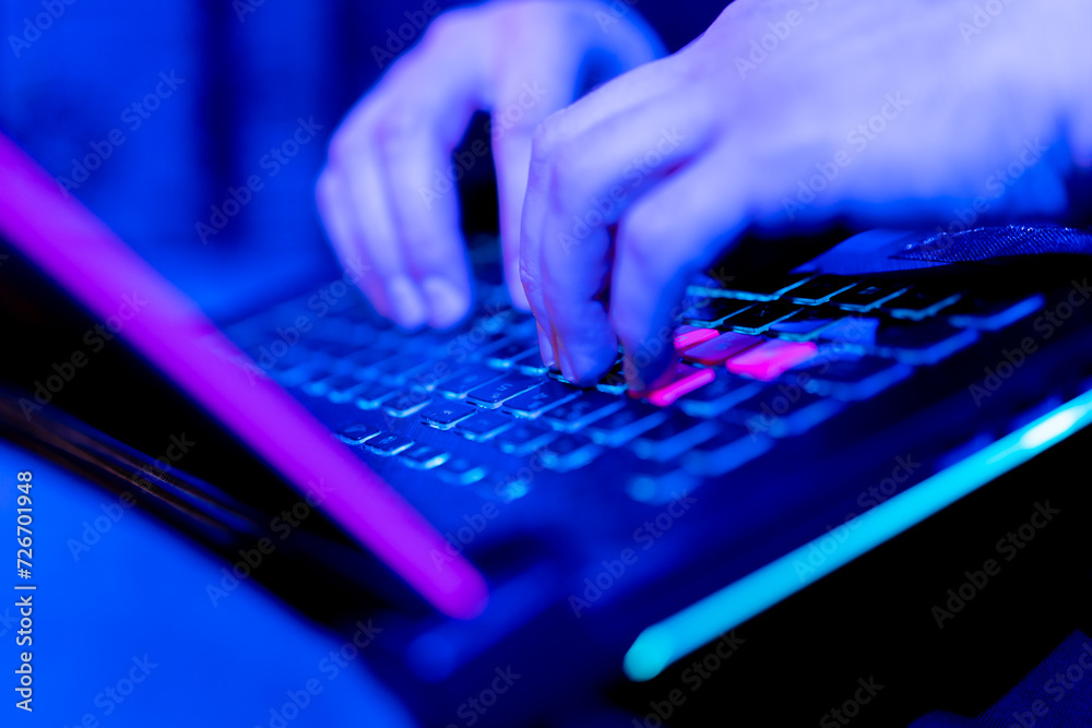 close-up of hands of hacker pressing keys on keyboard in data center vulnerable cyber security ...