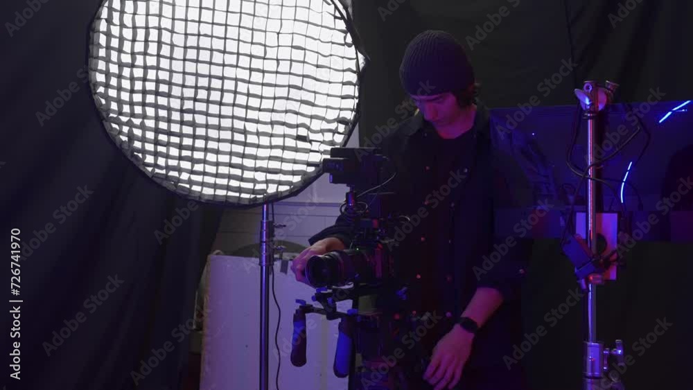 The videographer sets up the camera, and the lighting technician sets ...
