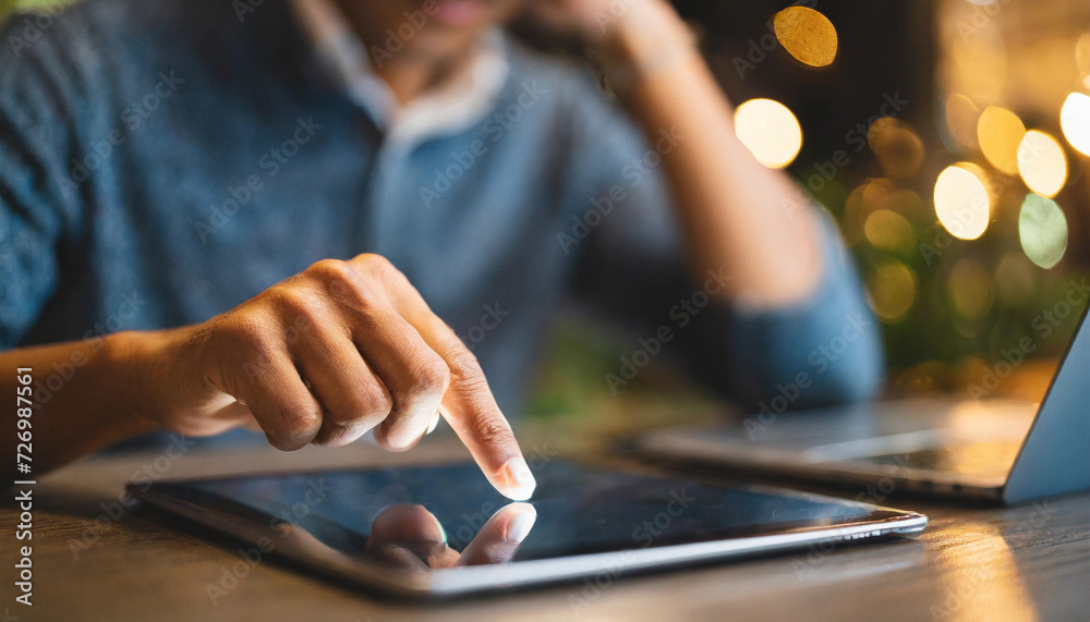 Hand taps on tablet in dim light, capturing the stress of digital ...