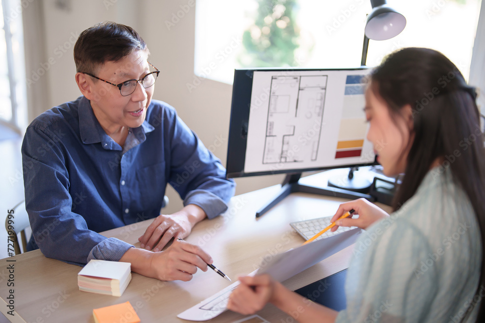 Interior designer women pointing on blueprint and explaining about ...