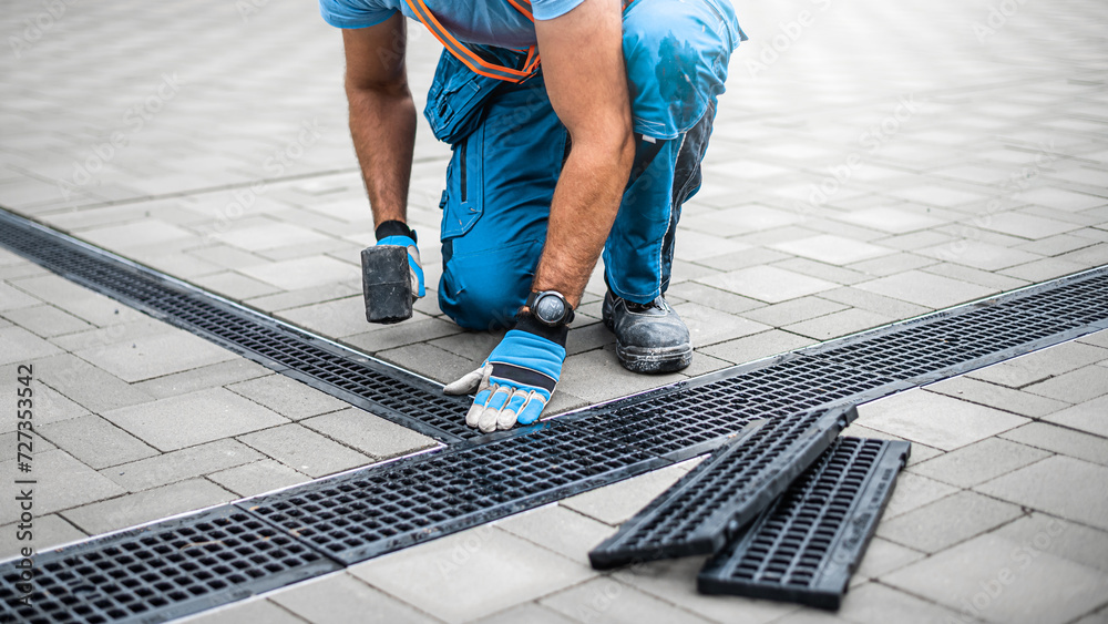 Laying interlocking paving. A worker is placing the grutter grid to ...
