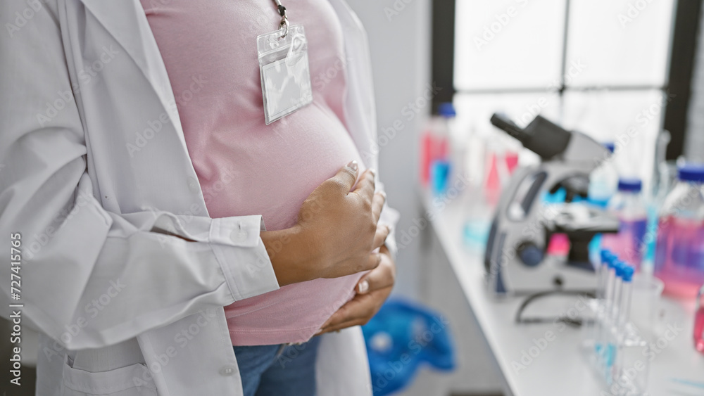Expecting hispanic woman scientist tenderly touching her pregnant belly ...