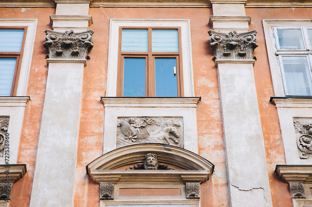 Old decorative architecture of Lviv, Ukraine.Windows on the red facade ...