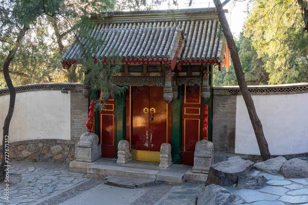 A traditional Chinese gate with concrete roof and densely ornamental ...
