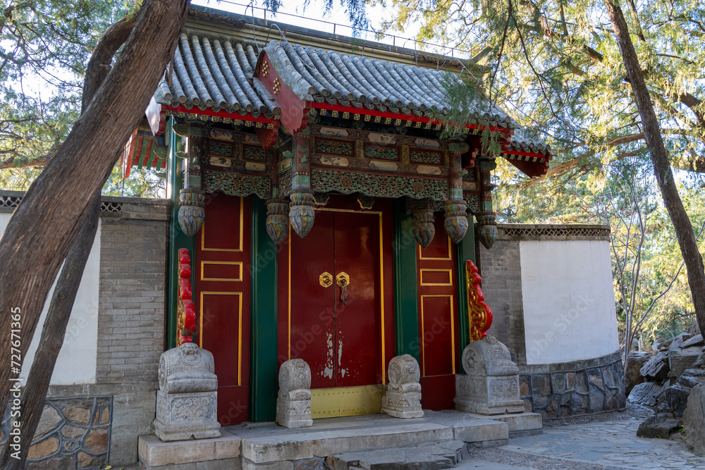 A traditional Chinese gate with concrete roof and densely ornamental ...