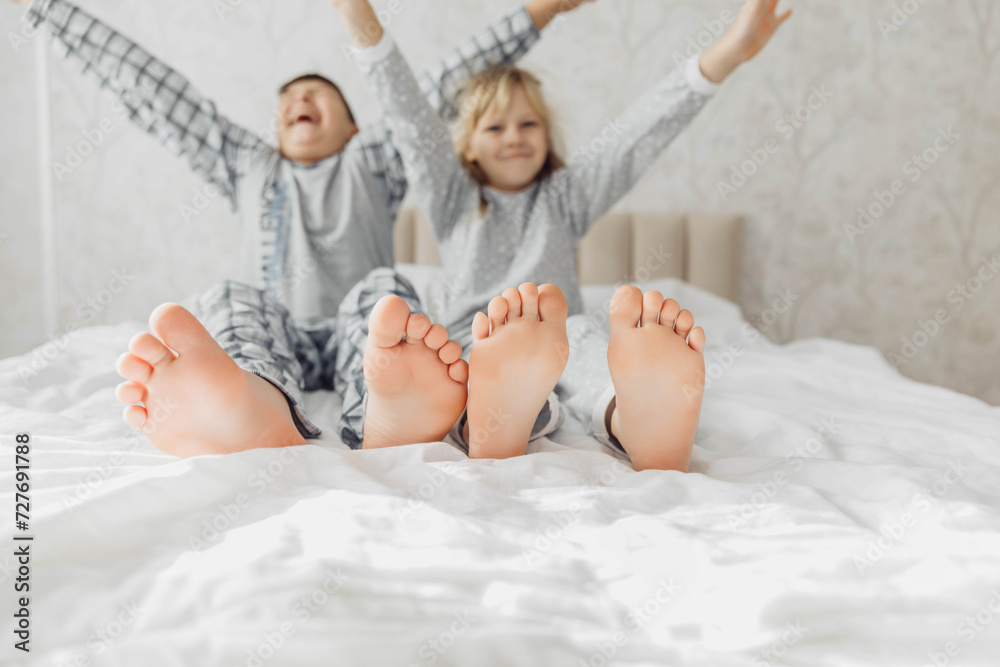 the bare, clean feet of two children, offspring, lying side by side ...