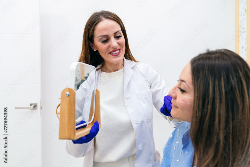 Patient in clinic looks at mirror while doctor shows the areas marked ...