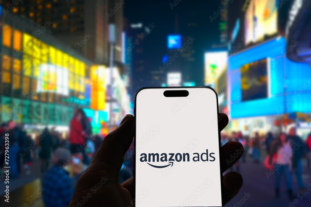 Amazon Ads logo is displayed on a smartphone, behind it the big ...