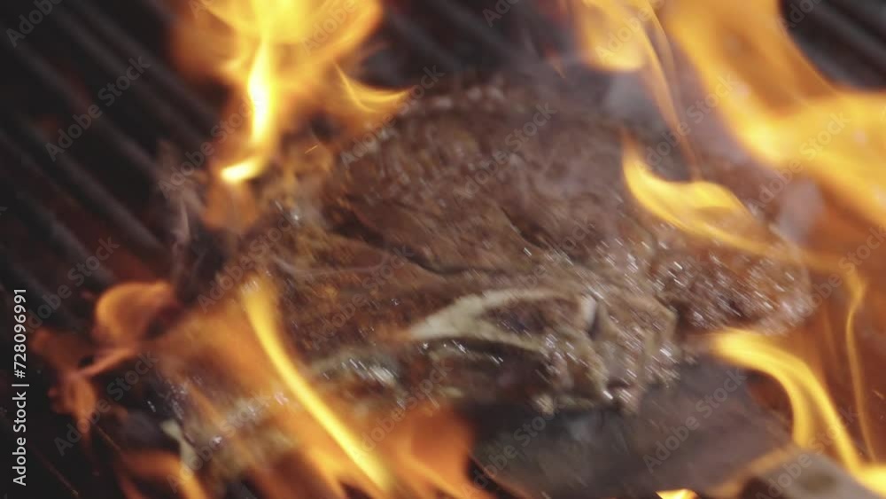 Roast beef with fire flames. Beef steak on grill with flames. Rib-eye ...