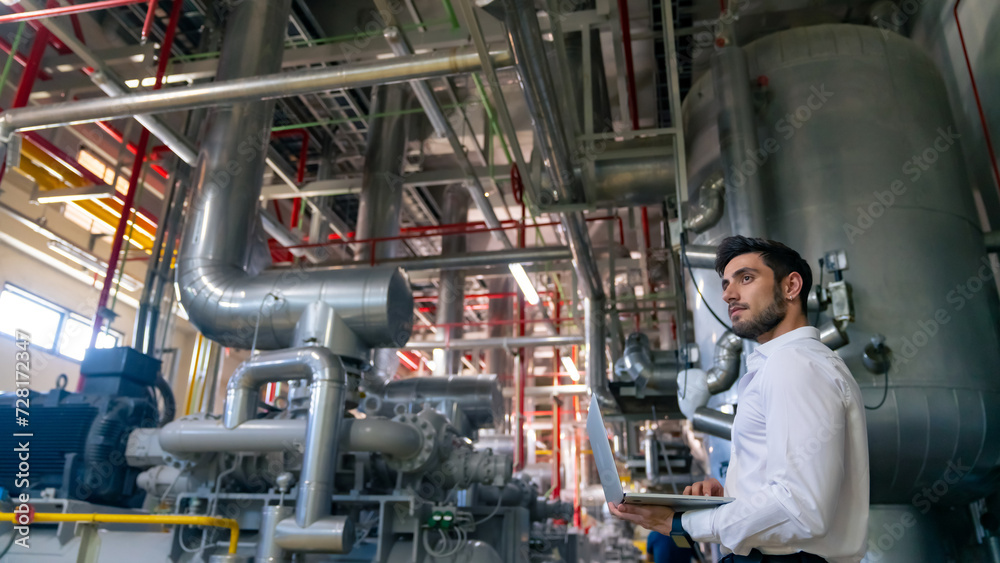 Professional male electrical engineer working on laptop computer at ...