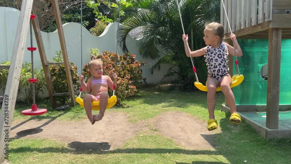 Two sisters swinging on a swing in swimsuits for 3-4 years Stock Video ...