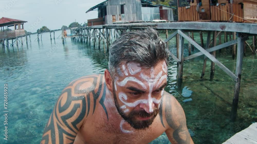 Vidéo Stock Angry man with Papua tribe facial painting comes from the ...