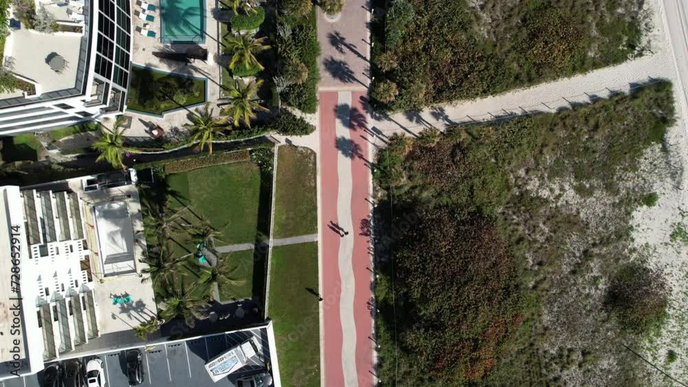 overhead drone video of a walk path by the beach on a bright sunny day ...