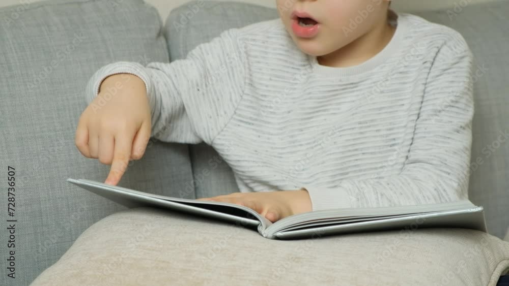 Vidéo Stock Elementary school child reading book, pointing finger at ...