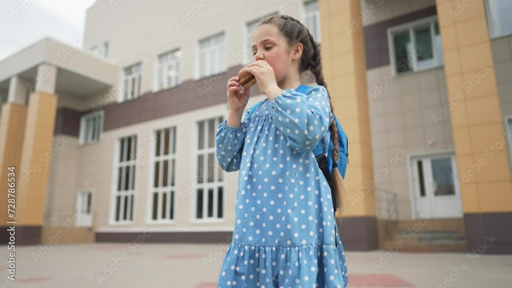 Girl having snack school.Schoolgirl takes food at recess.Happy ...