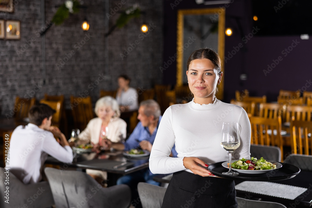 Smiling, positive waitress woman holds tray with order in hand and ...