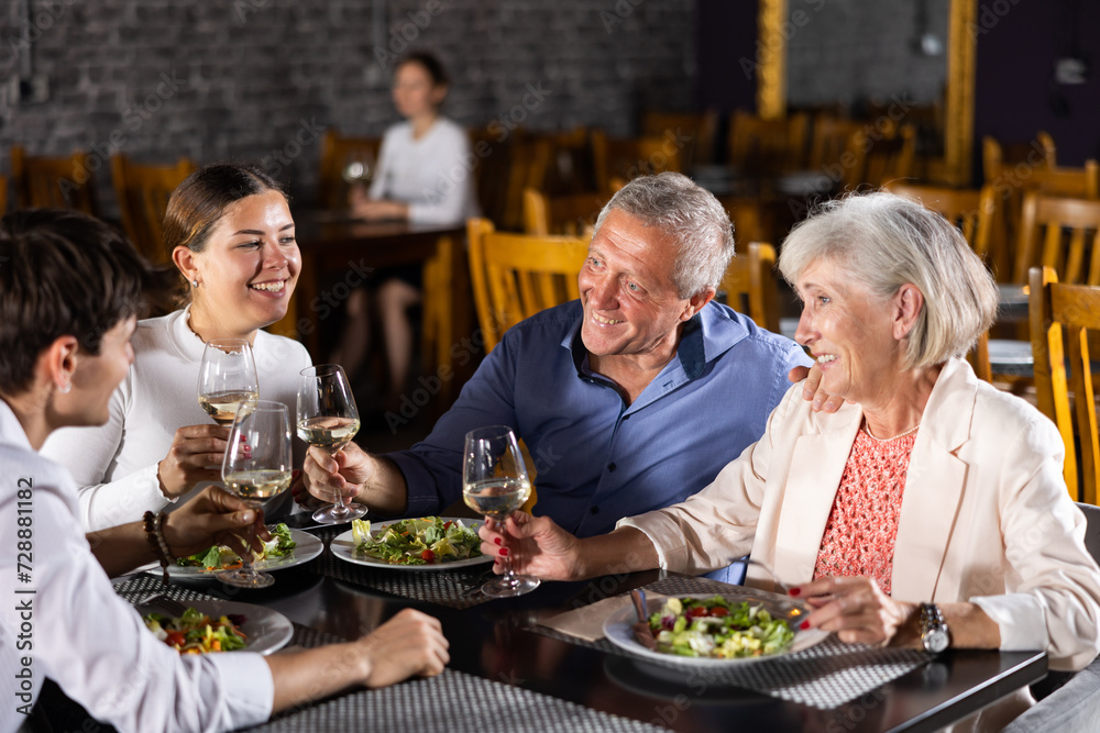 Elderly husband and wife with young married couple colleagues sitting ...