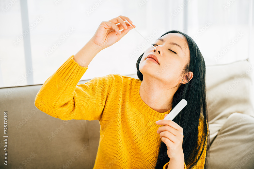 Highlighting self-testing for COVID-19, Asian woman at home uses a ...