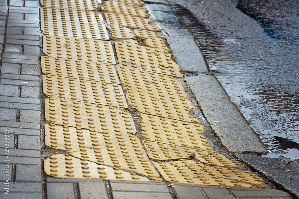 Rough cracked yellow cement braille brick. Broken yellow tactile tiles ...