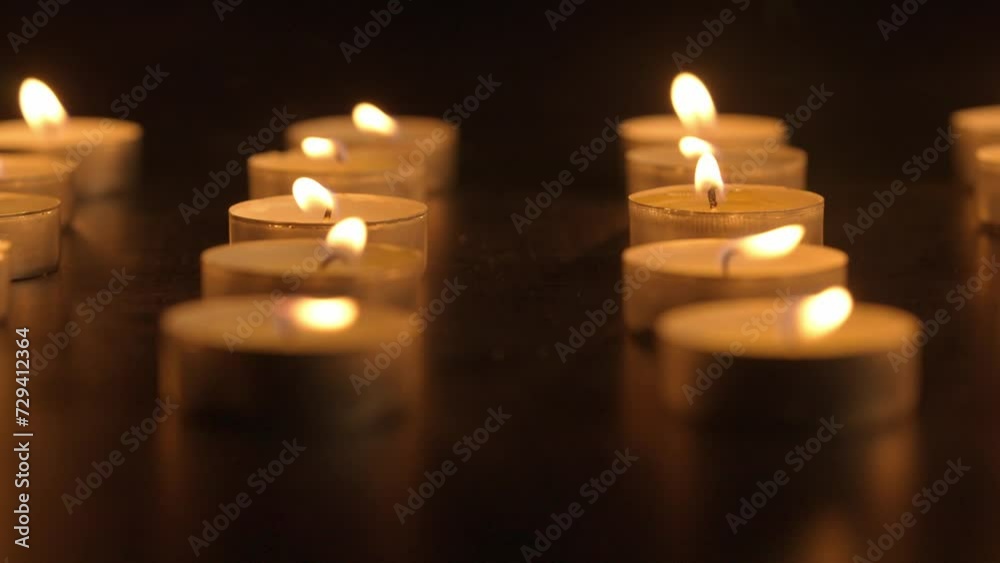 Video Stock Rows of burning candles. The candles burn against a black ...