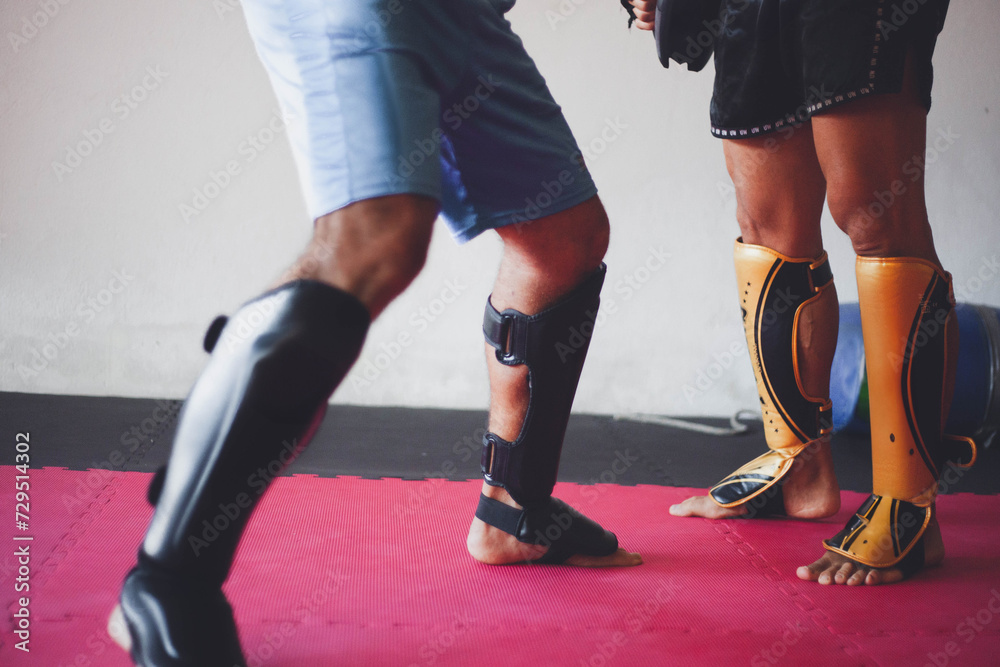Powerful Muay Thai fighters' legs, shielded by shin guards, showcase ...