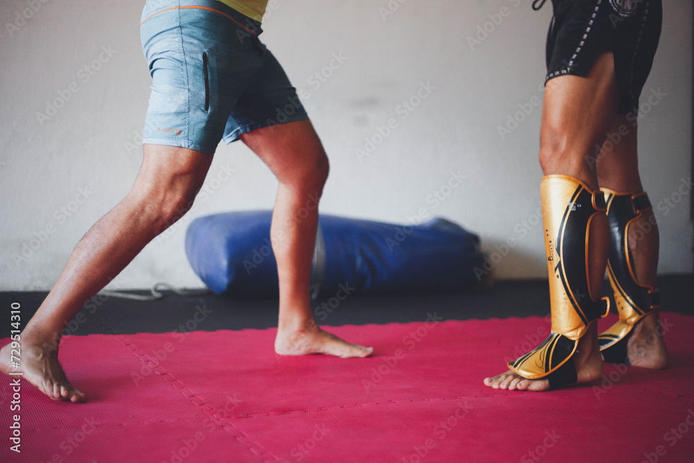Powerful Muay Thai fighters' legs, shielded by shin guards, showcase ...