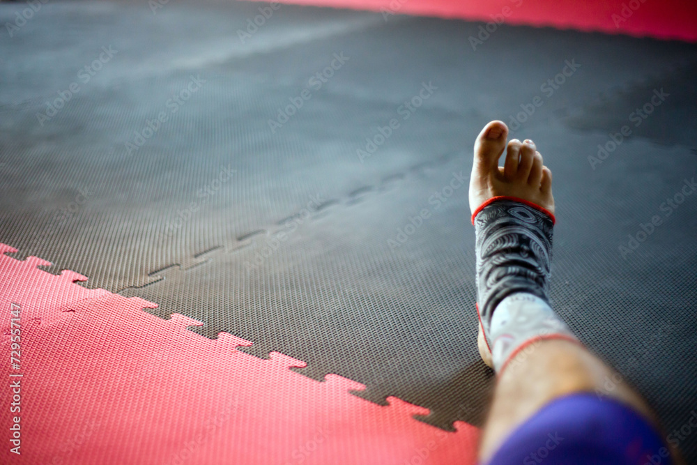 Powerful Muay Thai fighter's legs resting on the tatami, adorned with ...
