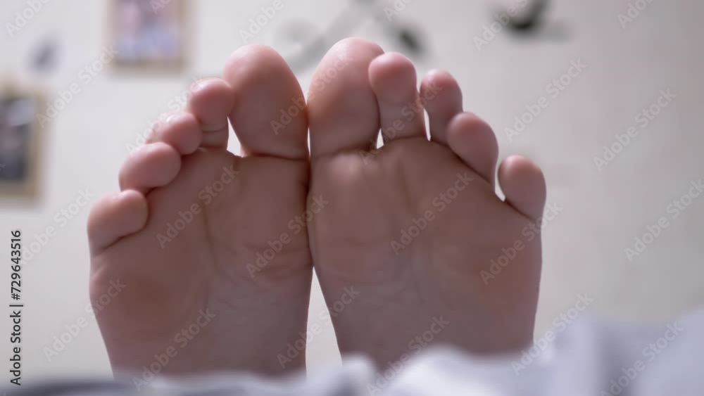 Close up, Person Moves Tired Legs in Pajamas on the Bed in the Bedroom ...