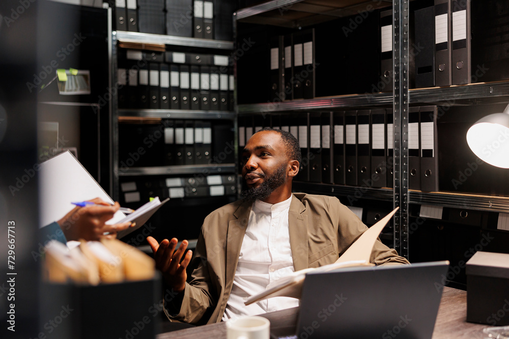 Detective discussing crime solving ideas with assistant in office at ...