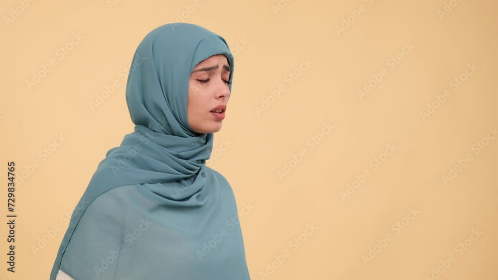 Vidéo Stock Portrait of a sad, serious Arab woman in hijab on a beige ...