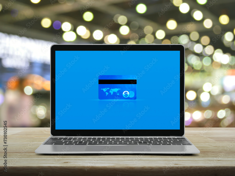 Credit card on modern laptop computer monitor screen on wooden table ...