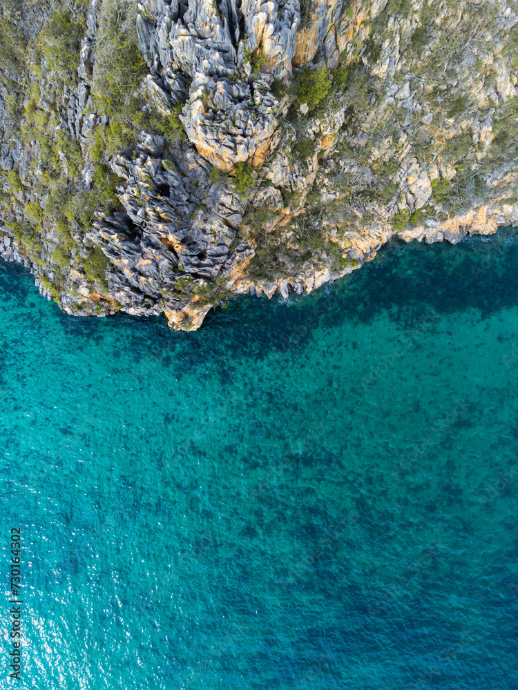 risco de una isla que da hacía el mar de aguas cristalinas Stock Photo ...