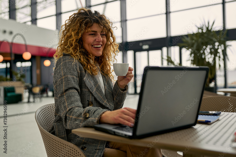 Successful and cheerful, a caucasian businesswoman takes notes ...