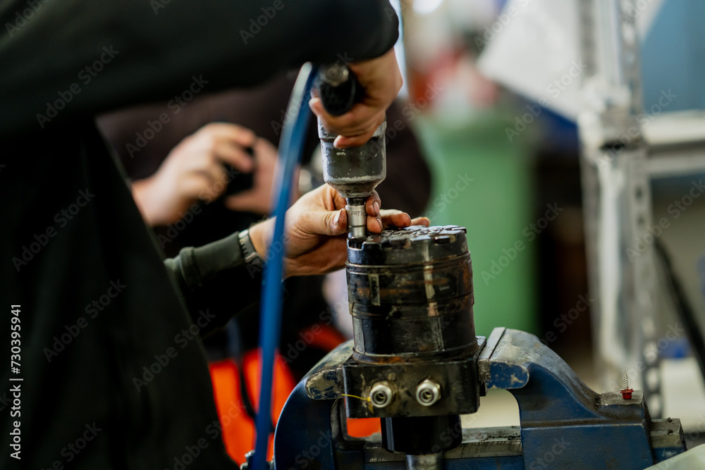 Mechanic hands using pneumatic gun on metal parts for enfgine repair ...