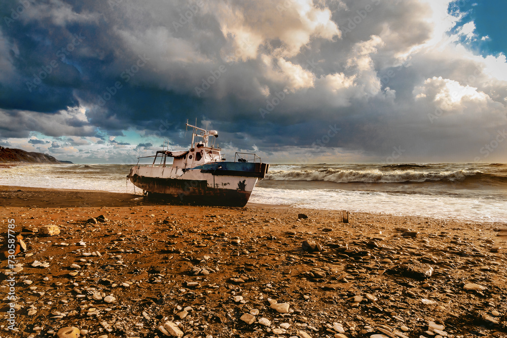 The wreck of a yacht in stormy weather. View of the beached ship. A ...
