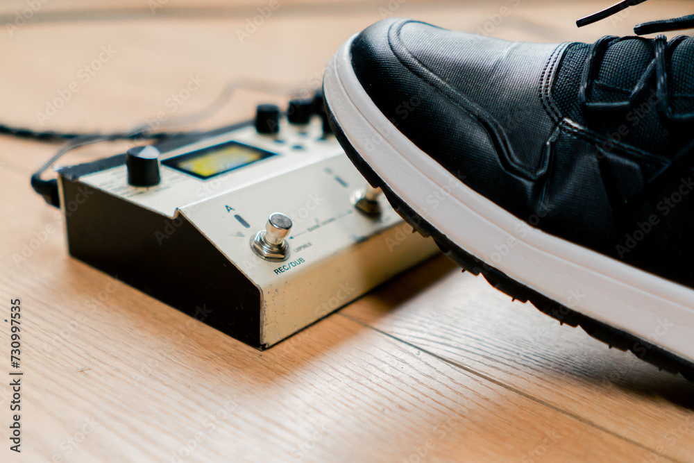 musician's male foot pressing bass drum pedal or bass electric guitar ...